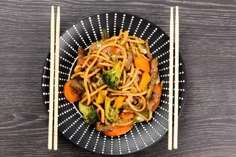 Yakisoba on a Black Plate with White Stripes on Dark Wood Table Stock ...