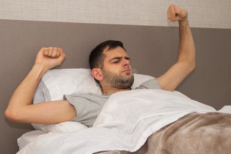 Man waking up in bed stock photo. Image of resting, male - 239614824