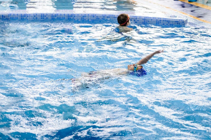 A 6-year Boy Swims Backstroke in a Swimming Pool Stock Photo - Image of ...