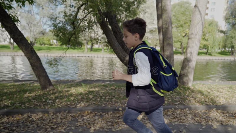 10 Year Caucasian Boy is Late for Classes at School. Boy is Running at ...