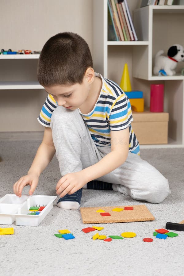 A 5-year-old Boy Creates a Picture from Multi-colored Pieces of a ...