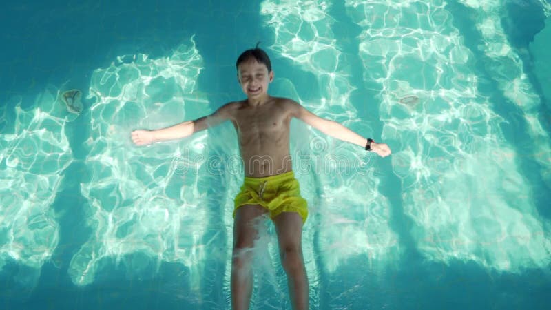 9 Year Old Boy Falling into the Pool with Blue Water. Splashes Fly in ...