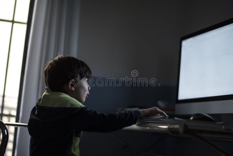 4 Year Old Boy Handles the Computer in a Dark Environment at Home Stock ...