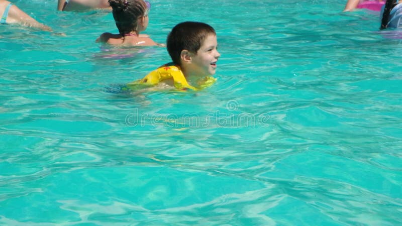 A 5-year-old Boy is Learning To Swim in an Inflatable Vest in a Pool ...