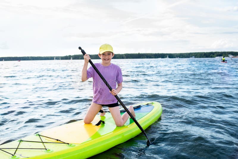 A 10-year-old Boy Rides a SUP Board on a River or Lake Alone Stock ...