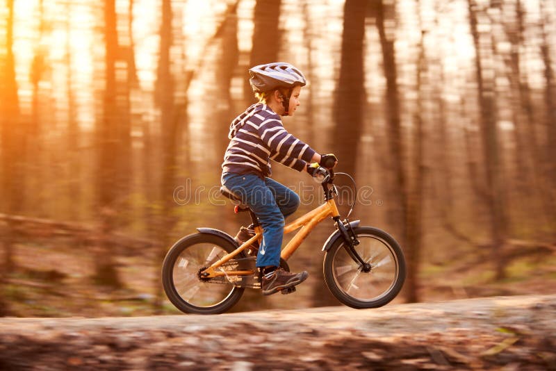 6 Year Old Boy Riding Bike at Sunset in the Forest, Motion Blur Stock ...