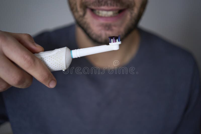 A 30-year-old Man Brushes His Teeth with Purple Toothpaste Using an ...