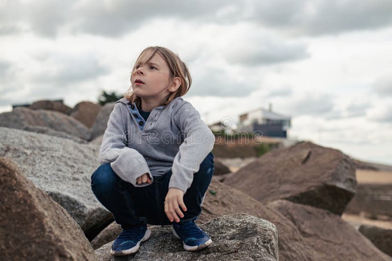 A 10-year-old Young Boy Deep in Thought, Seated on Large Rocks Stock ...