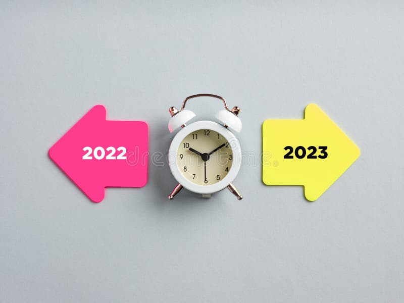 The Year 2022 and 2023 Written on Arrow Note Papers Next To a Clock ...