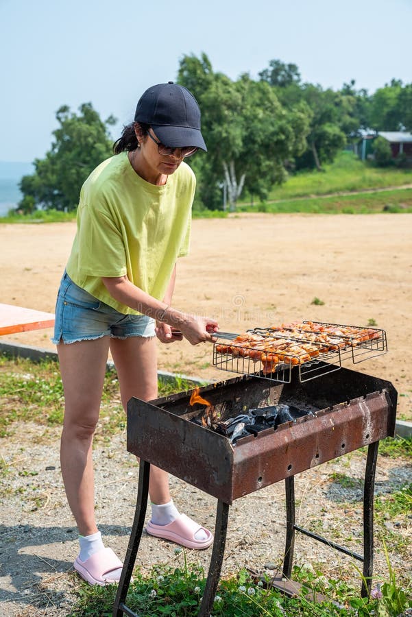 50 Years Old Woman Cooking Bbq Pork Outdoors Stock Photo - Image of ...