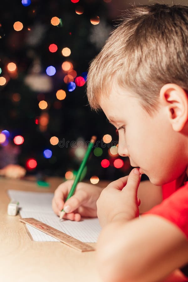 7 Yeas Old Boy Sitting at Desk and Doing Homework Stock Image - Image ...