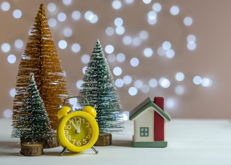 Yellow Alarm Clock, Small House and Christmas Trees on the Table Stock ...