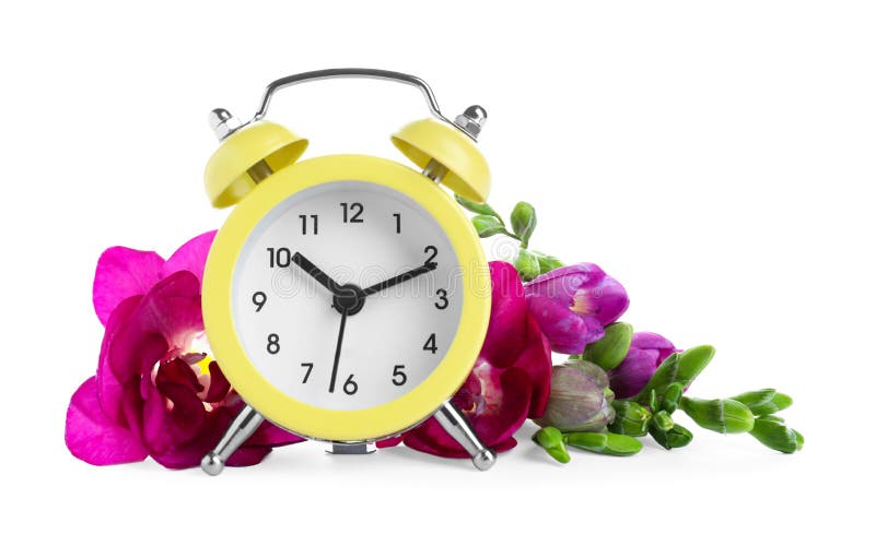 Yellow Alarm Clock and Spring Flowers on Background. Time Change Stock ...