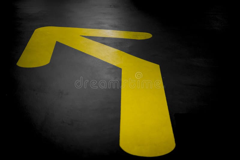 Yellow Arrow on a Dark Asphalt Surface, Pointing Towards the Upper Left ...
