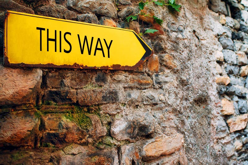 Yellow Arrow Sign on Old Stone Brick Wall. Direction Pointer with ...