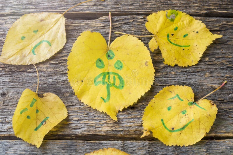 Yellow Autumn Leaves with Smiley Patterns on Wooden Background. Stock ...