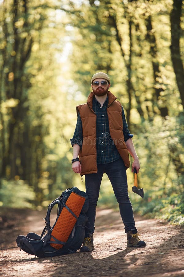 Yellow Axe in Hand, Backpack on the Ground. Bearded Man is in the ...
