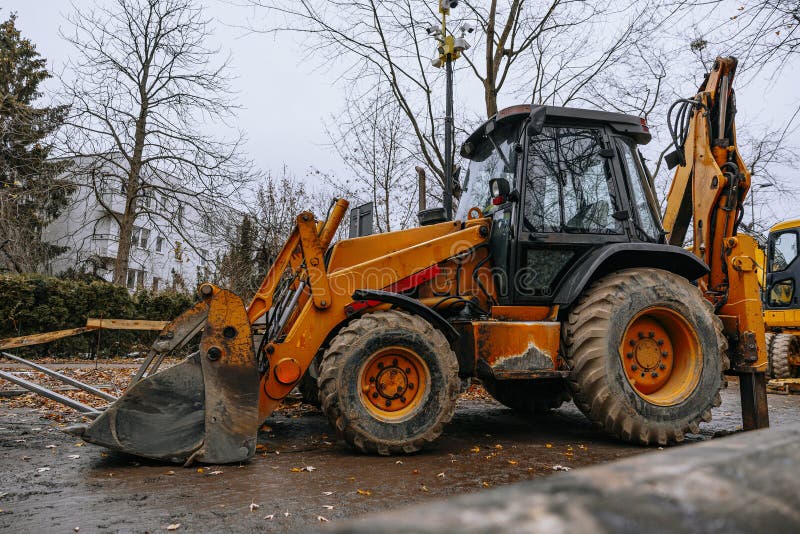 Yellow Backhoe Loader Parked at a Muddy Construction Site Surrounded by ...