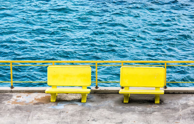 Yellow Benches by Blue Water Stock Photo - Image of yellow, bench: 58931170