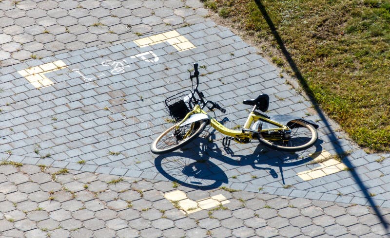 A Yellow Bicycle is Laying on the Ground in Front of a Bike Rack ...