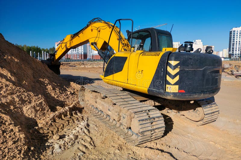 A Yellow and Black Bulldozer Actively Digging into a Pile of Dirt at a ...