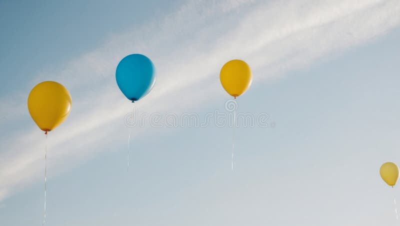 Yellow and Blue Balloons Float Across a Clear Sky. Stock Image - Image ...