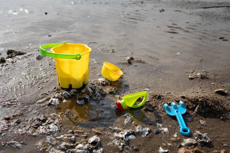 Yellow Bucket with a Green Handle is on the Beach Stock Image - Image ...