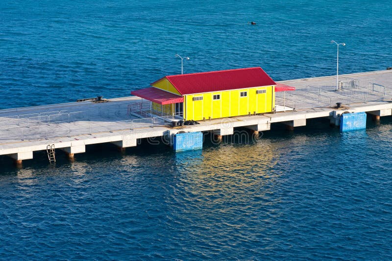 Yellow Building with Red Roof Over Blue Water Stock Photo - Image of ...
