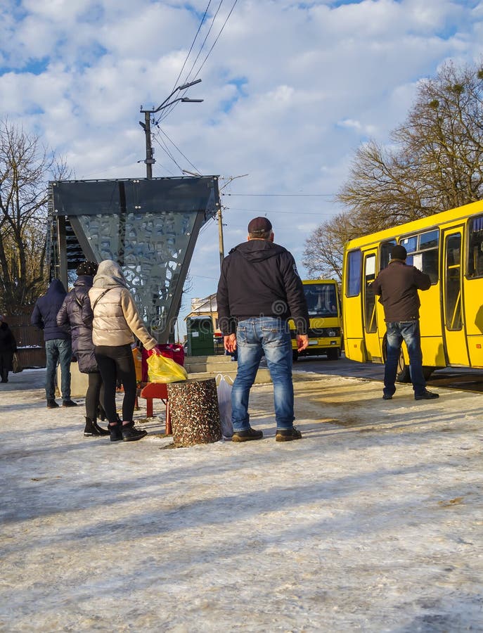 Yellow Buses Approaching a Bus Stop with Passengers Waiting for Them ...