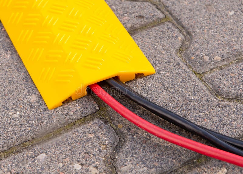 Yellow Cable Protector on Paved Surface Stock Image - Image of cover ...