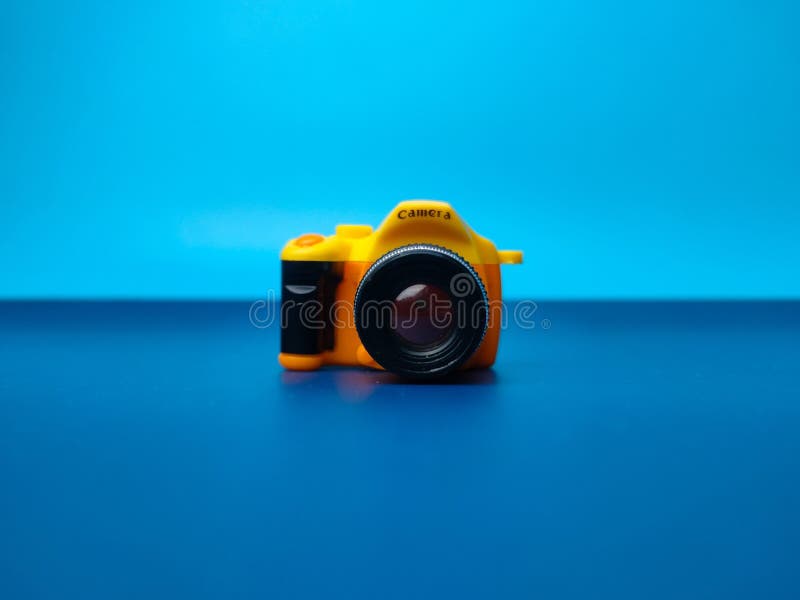 Yellow Camera in the Middle with a Blue Background Stock Image - Image ...