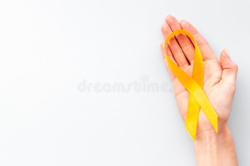 Yellow Cancer Awareness Ribbon in Hand. Top View Stock Photo - Image of ...