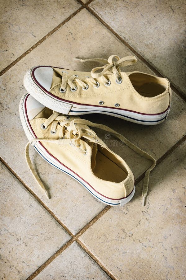 Yellow Canvas Running Shoes on a Tile Floor. Stock Photo - Image of ...