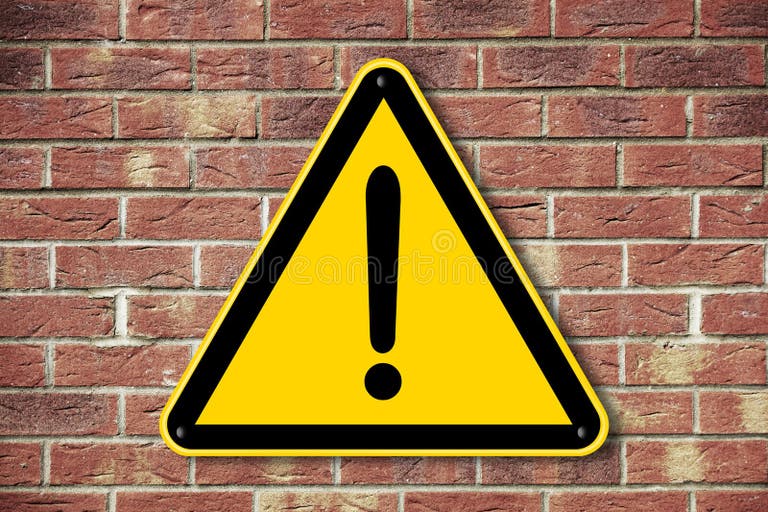 Yellow Caution Triangle Sign on a Brick Wall Stock Image - Image of ...