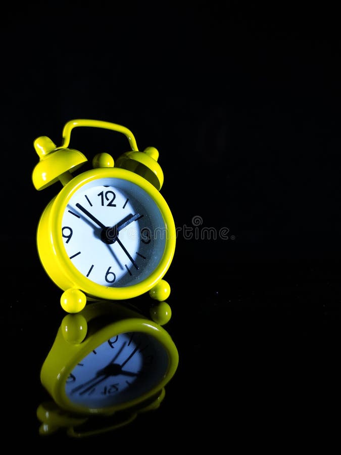 A Yellow Clock with Reflection on a Black Background. Stock ...
