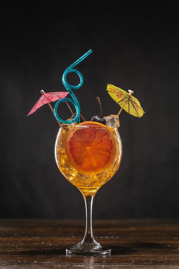 Yellow Cocktail with Cherry in a Glass Standing on a Wooden Table ...