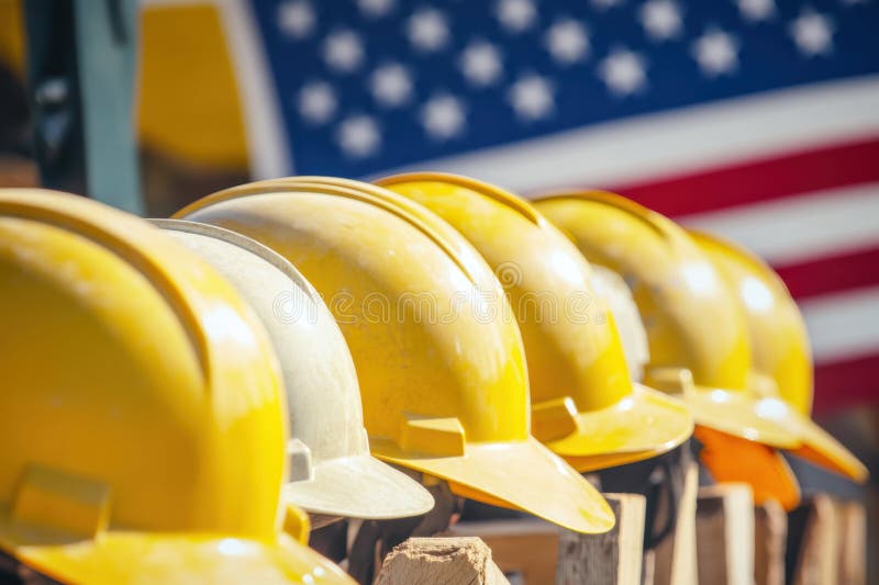 Yellow Construction Helmets in a Line with American Flag in Background ...