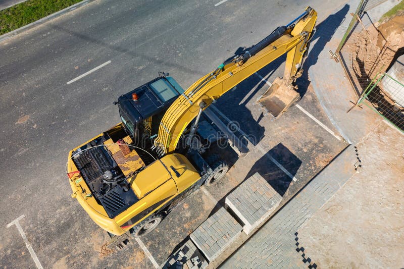 A Yellow Construction Vehicle is Parked on the Side of a Road, Ready ...