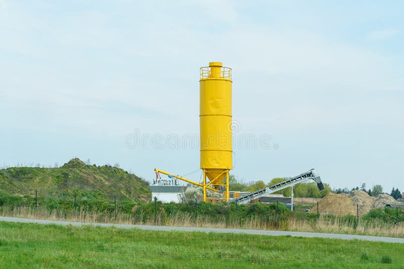 A Yellow Container for Concrete Mixers and an Elevator for Loading Dump ...