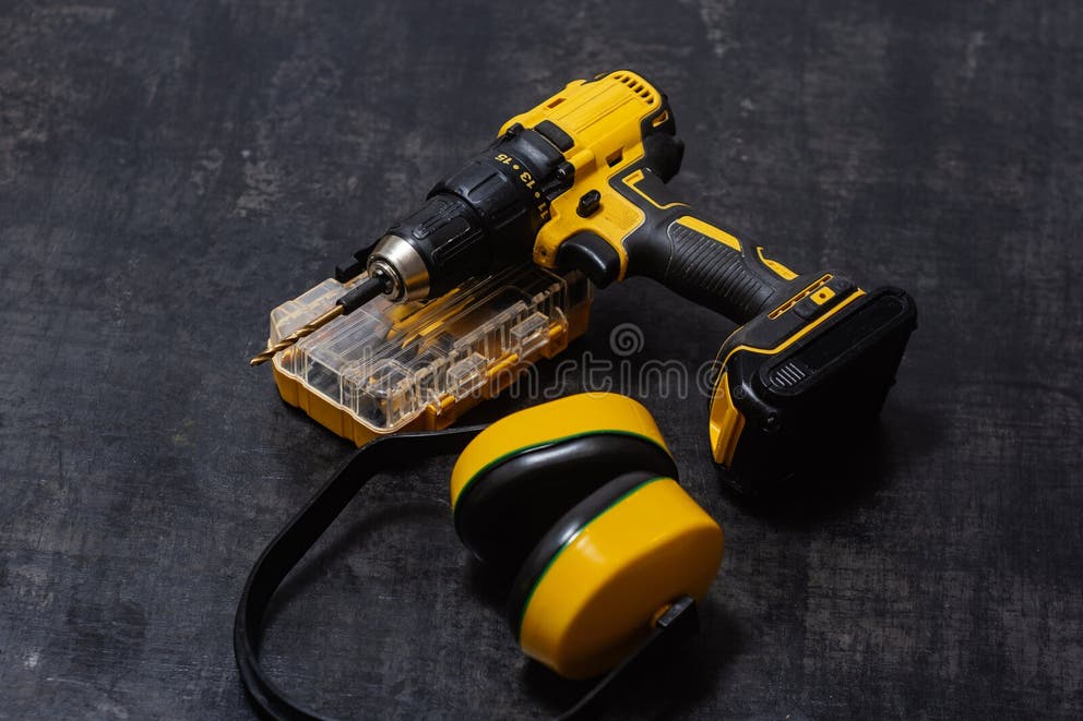 Yellow Cordless Drill Drill with Ear Protection and Bits on Dark ...