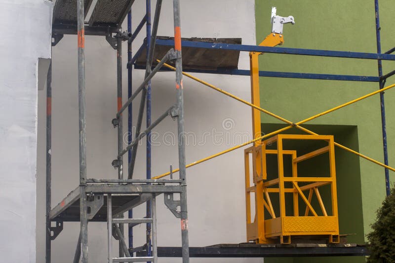 Yellow Cradle on Scaffolding Stock Photo - Image of climbing, lift ...
