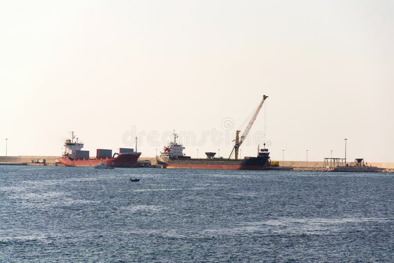 Yellow Crane Unloading Sand from Large Freighter Cargo Ship in Harbor ...