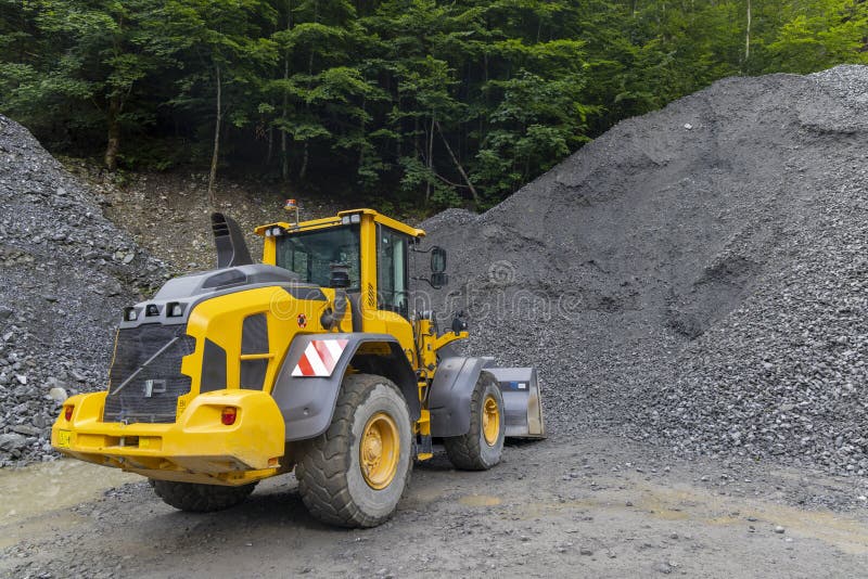 Yellow Digger with Grey Gravel for Construction of the Road Stock Photo ...