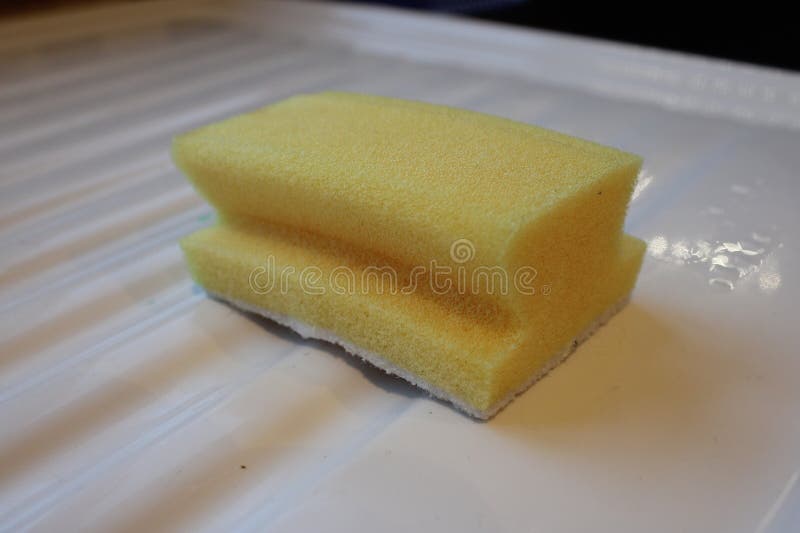 Yellow Dish Washer Sponge Sitting on a Ceramic Kitchen Draining Board ...