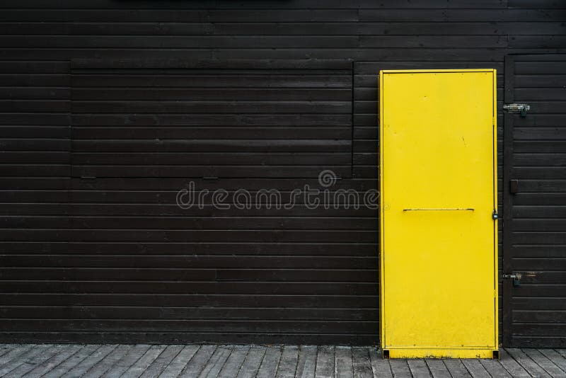 Yellow door by black wall stock image. Image of wooden - 247484157