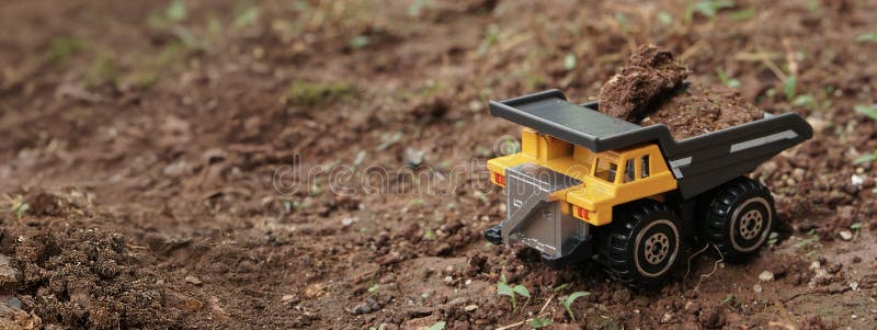 Yellow Dump Truck Toy Model Loading Soil on the Ground. Wide ...