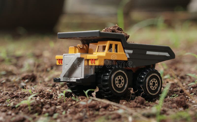 Yellow Dump Truck Toy Model Transporting Soil on the Ground ...