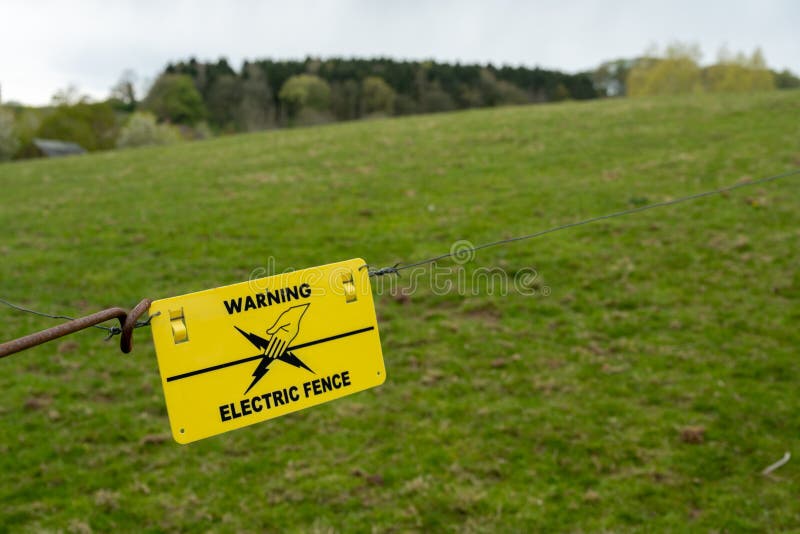 A Yellow Electric Fence Warning Sign Stock Photo - Image of fence ...