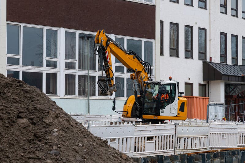 Yellow Excavator at a Construction Site Against a Building Stock Photo ...
