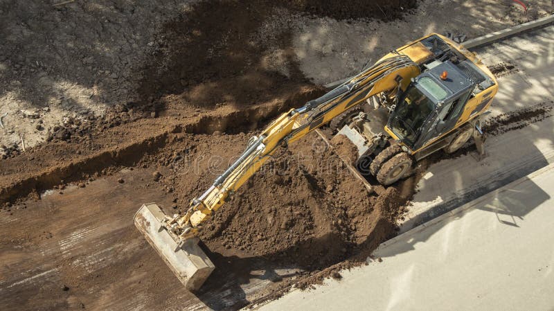 Yellow Excavator Digs a Hole at a Construction Site, Top View Stock ...
